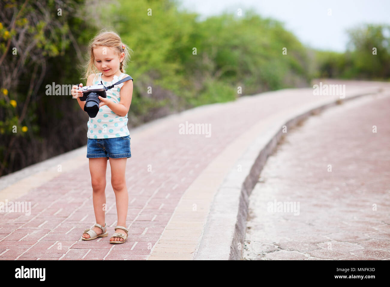 Adorable little girl with photo camera Stock Photo - Alamy