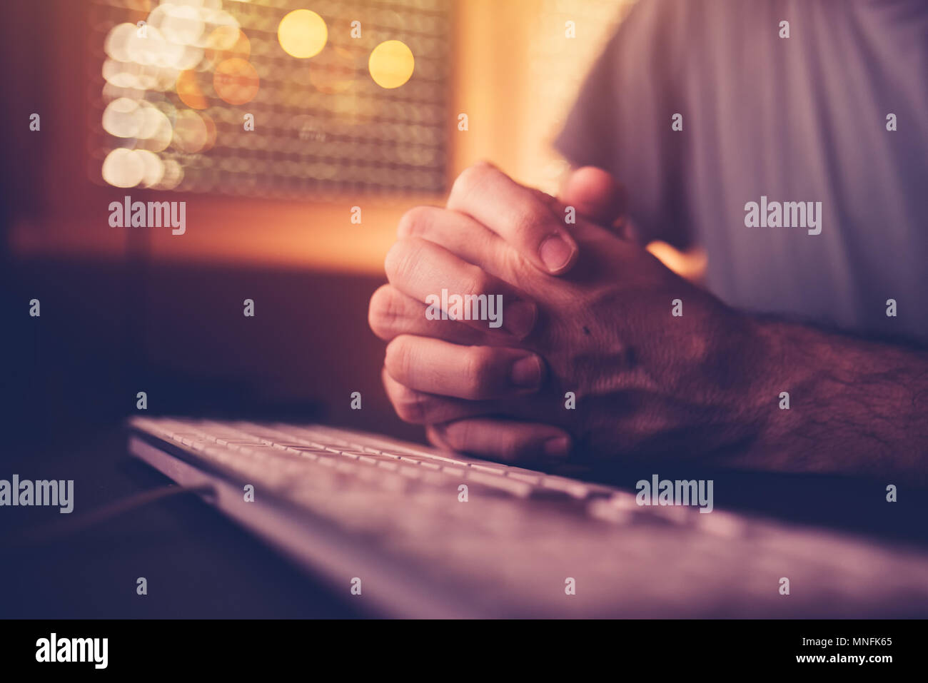 Pray over computer keyboard. Male hands clenched or clasped in praying ...