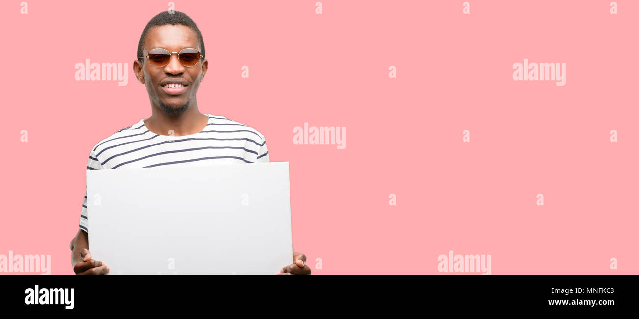 African black man wearing sunglasses holding blank advertising banner ...