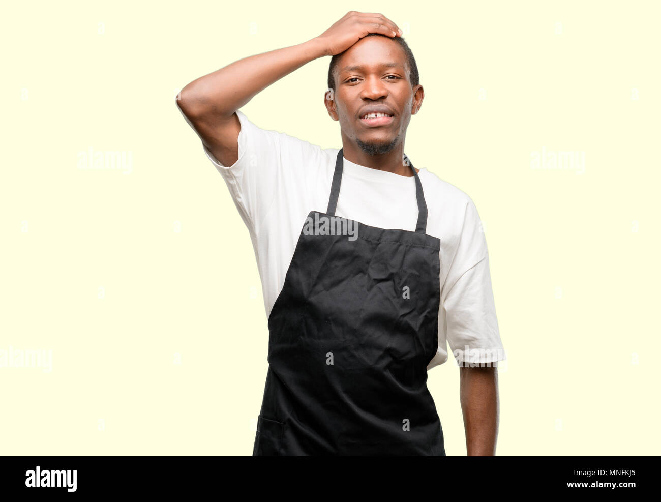 African man shop owner wearing apron terrified and nervous expressing ...
