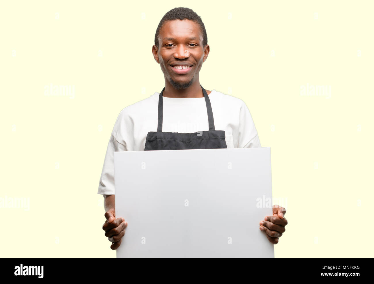 African man shop owner wearing apron holding blank advertising banner ...