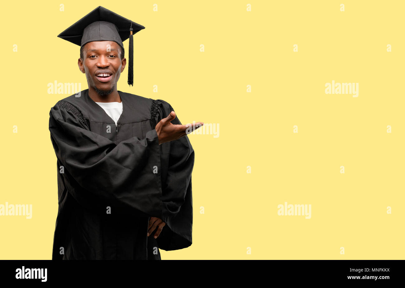 Young african graduate student black man holding something in empty ...