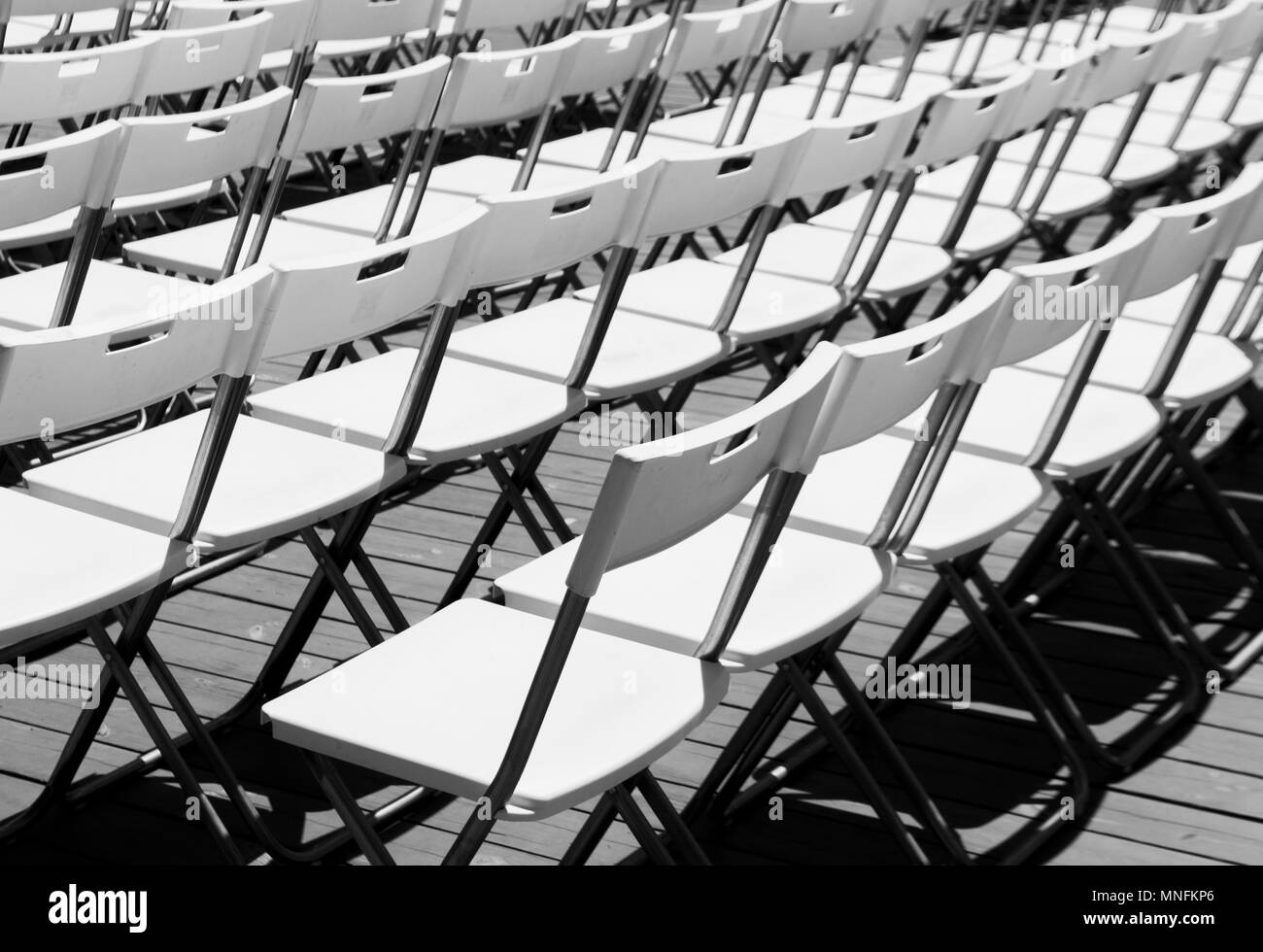 Rows of white empty folding chairs in a summer theatre Stock Photo - Alamy
