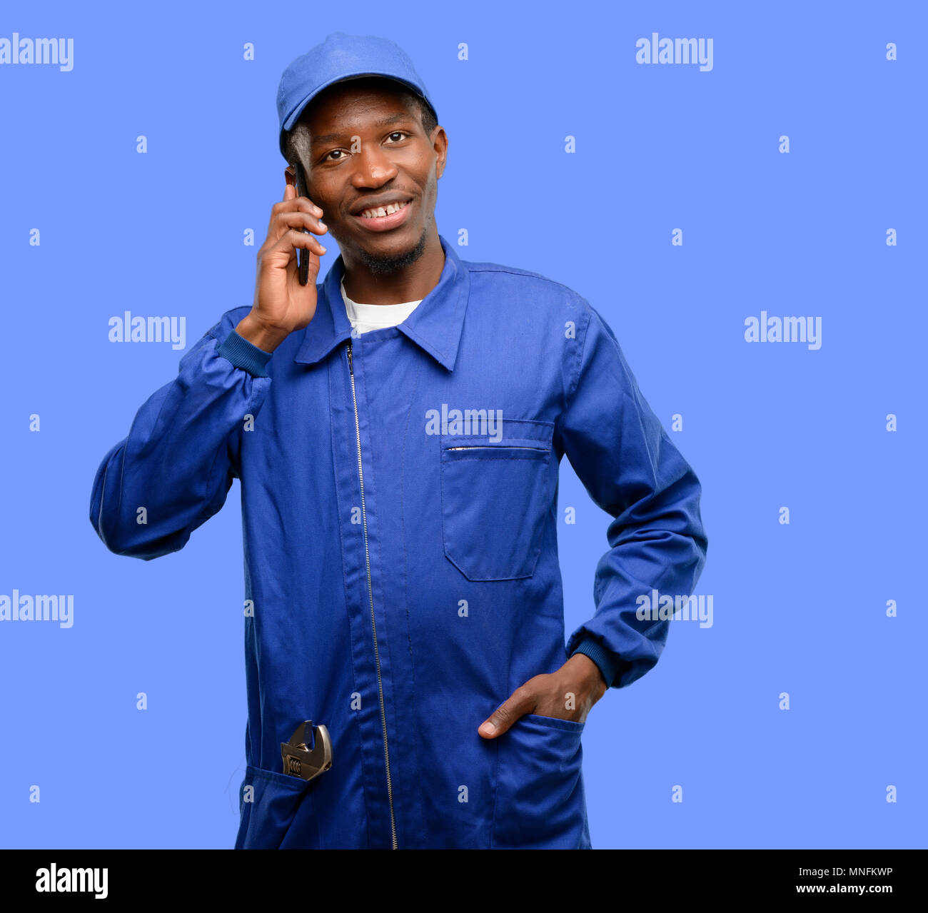African black plumber man happy talking using a smartphone mobile phone ...