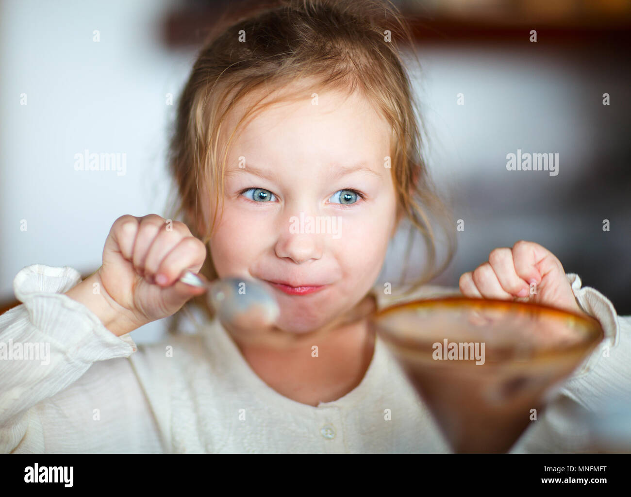 Cute little girl eating dessert at restaurant Stock Photo - Alamy