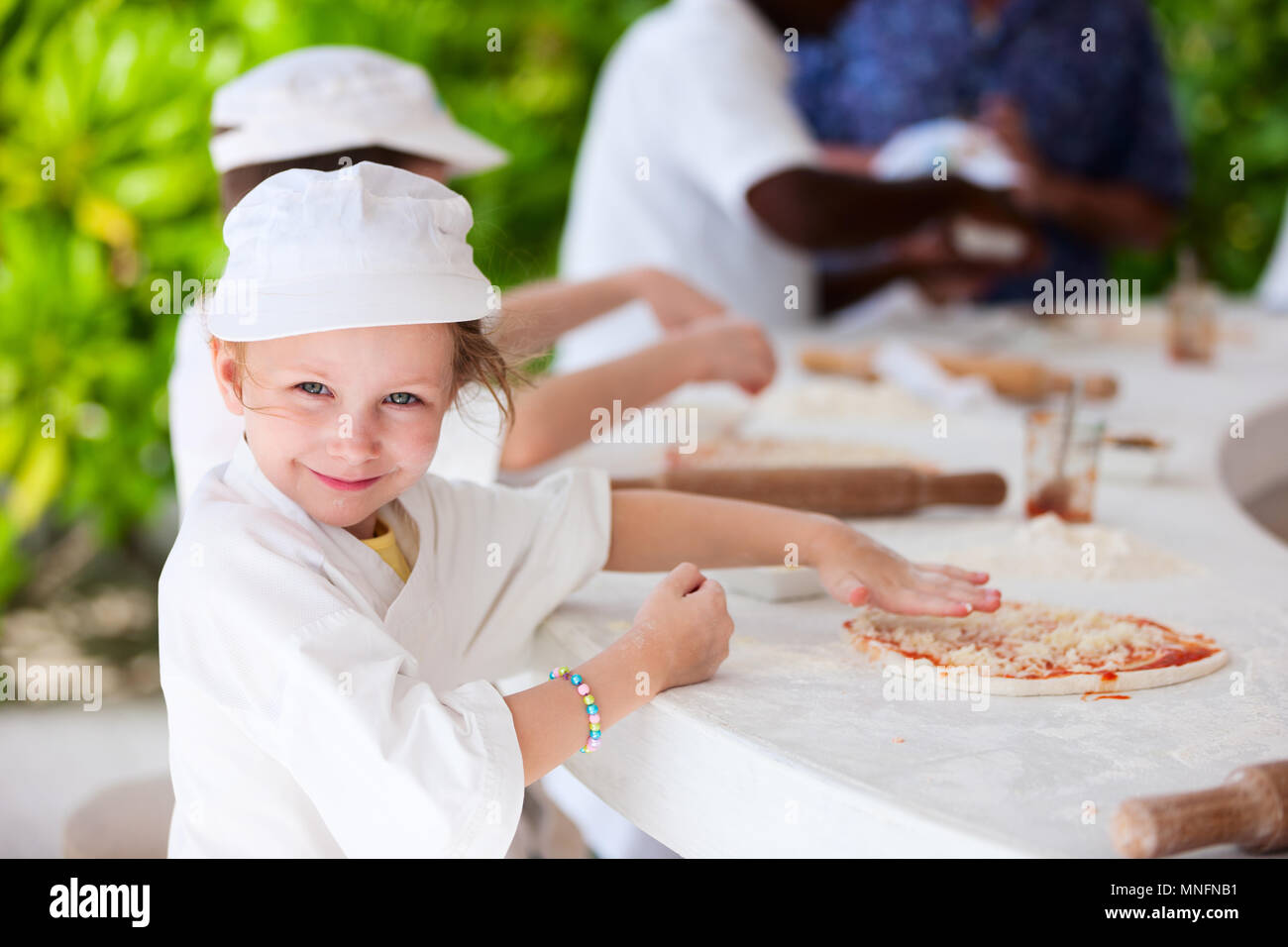 Adorable little girl dressed as a chef making pizza Stock Photo - Alamy