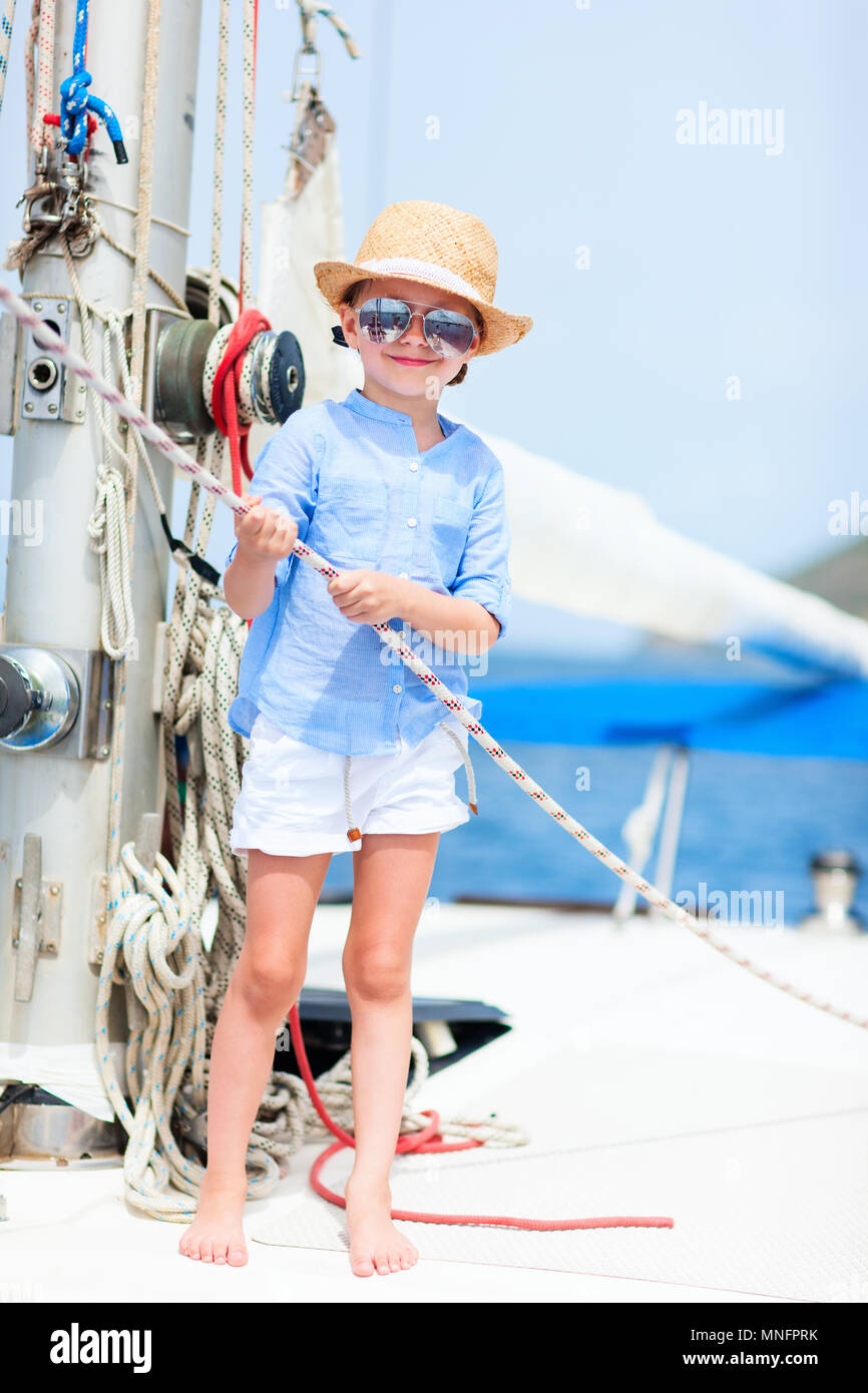 Adorable little girl enjoying sailing on a luxury catamaran or yacht ...