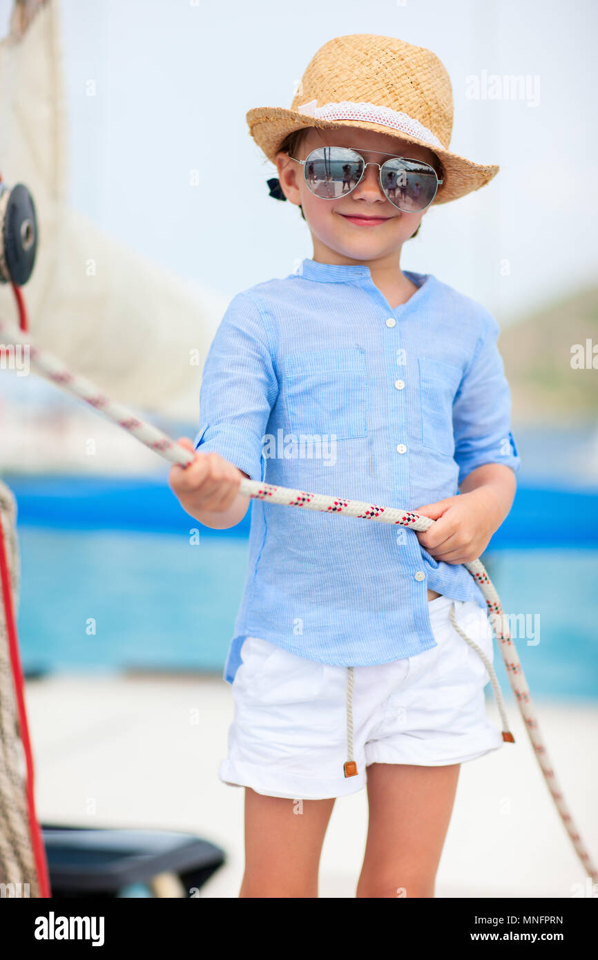 Adorable little girl enjoying sailing on a luxury catamaran or yacht ...