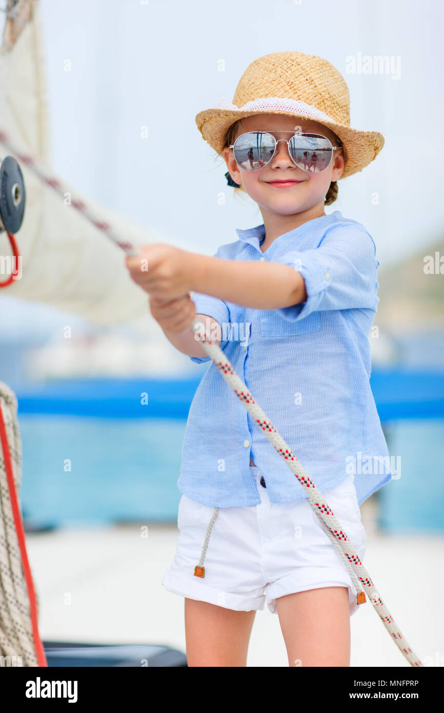 Adorable little girl enjoying sailing on a luxury catamaran or yacht ...