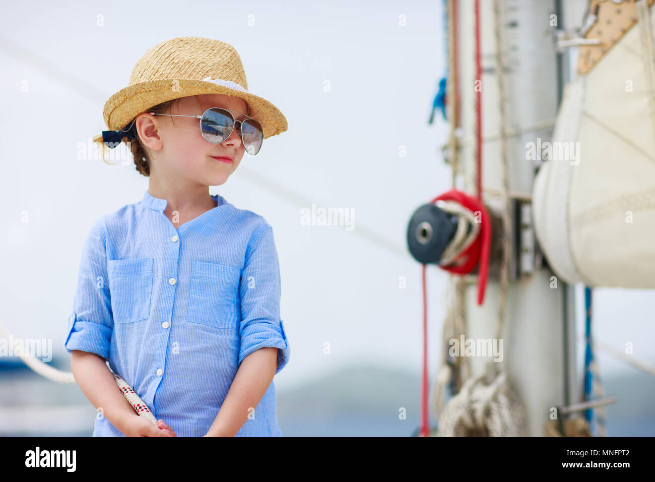 Adorable little girl enjoying sailing on a luxury catamaran or yacht ...