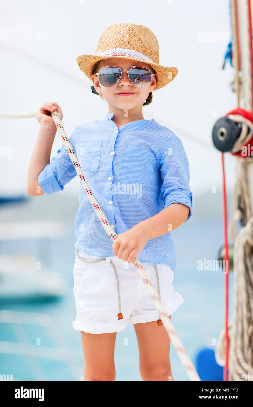 Adorable little girl enjoying sailing on a luxury catamaran or yacht ...