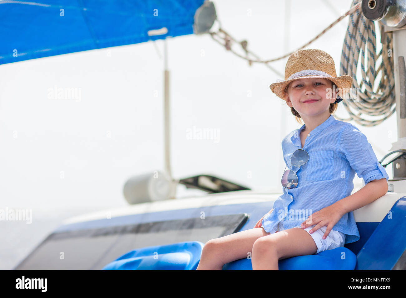 Adorable little girl enjoying sailing on a luxury catamaran or yacht ...