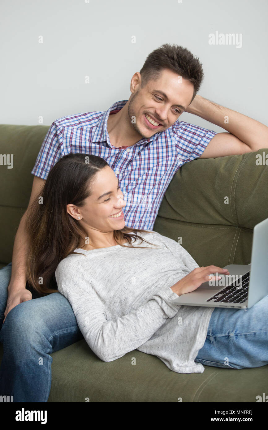 Happy couple watching video at laptop together Stock Photo - Alamy