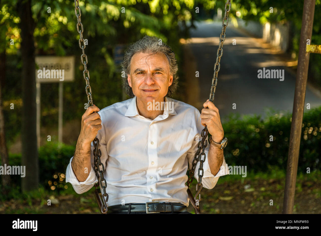 man on swing in green garden Stock Photo - Alamy