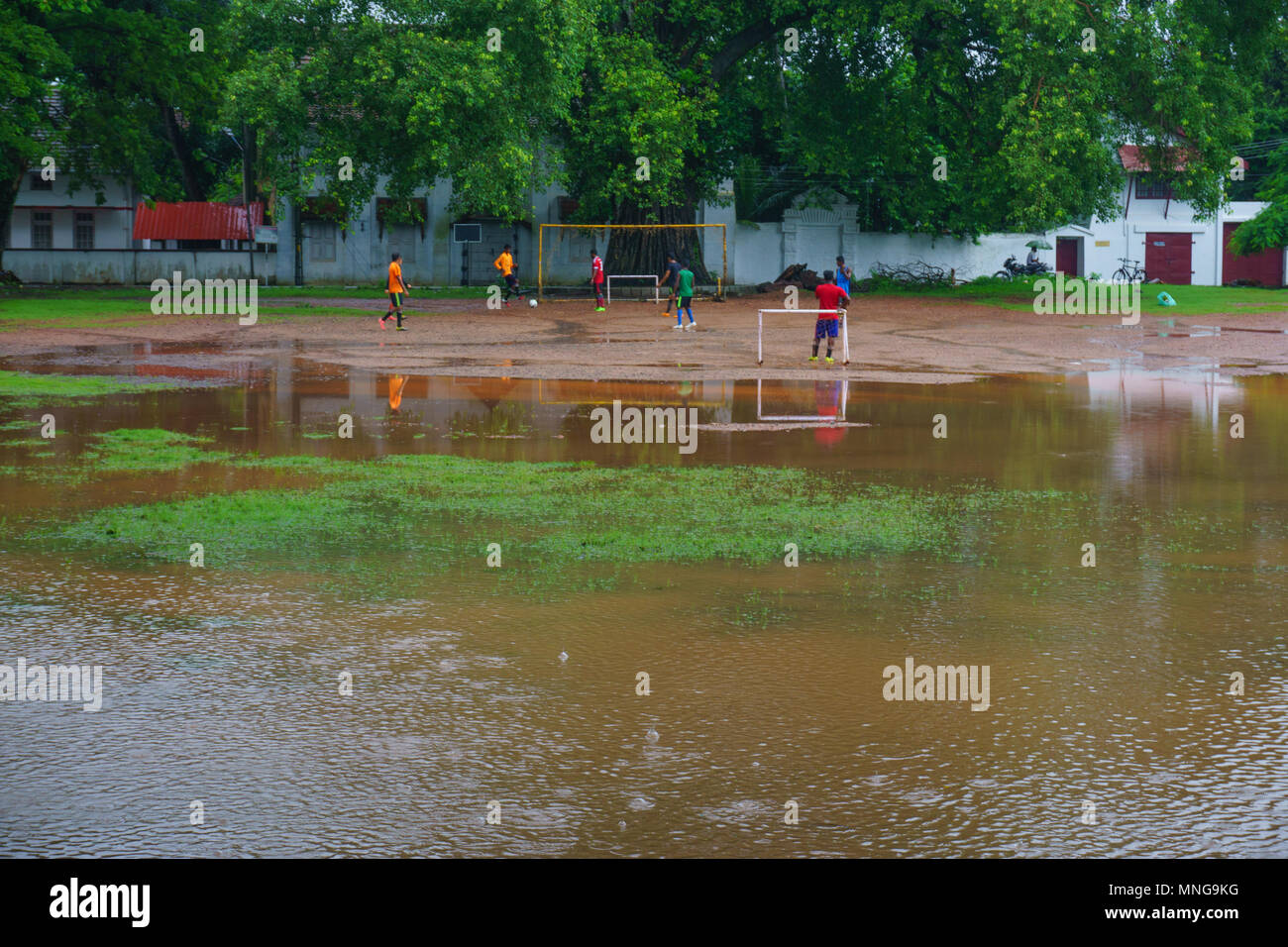 Local boys are playing football in the rain-drenched field at Fort ...