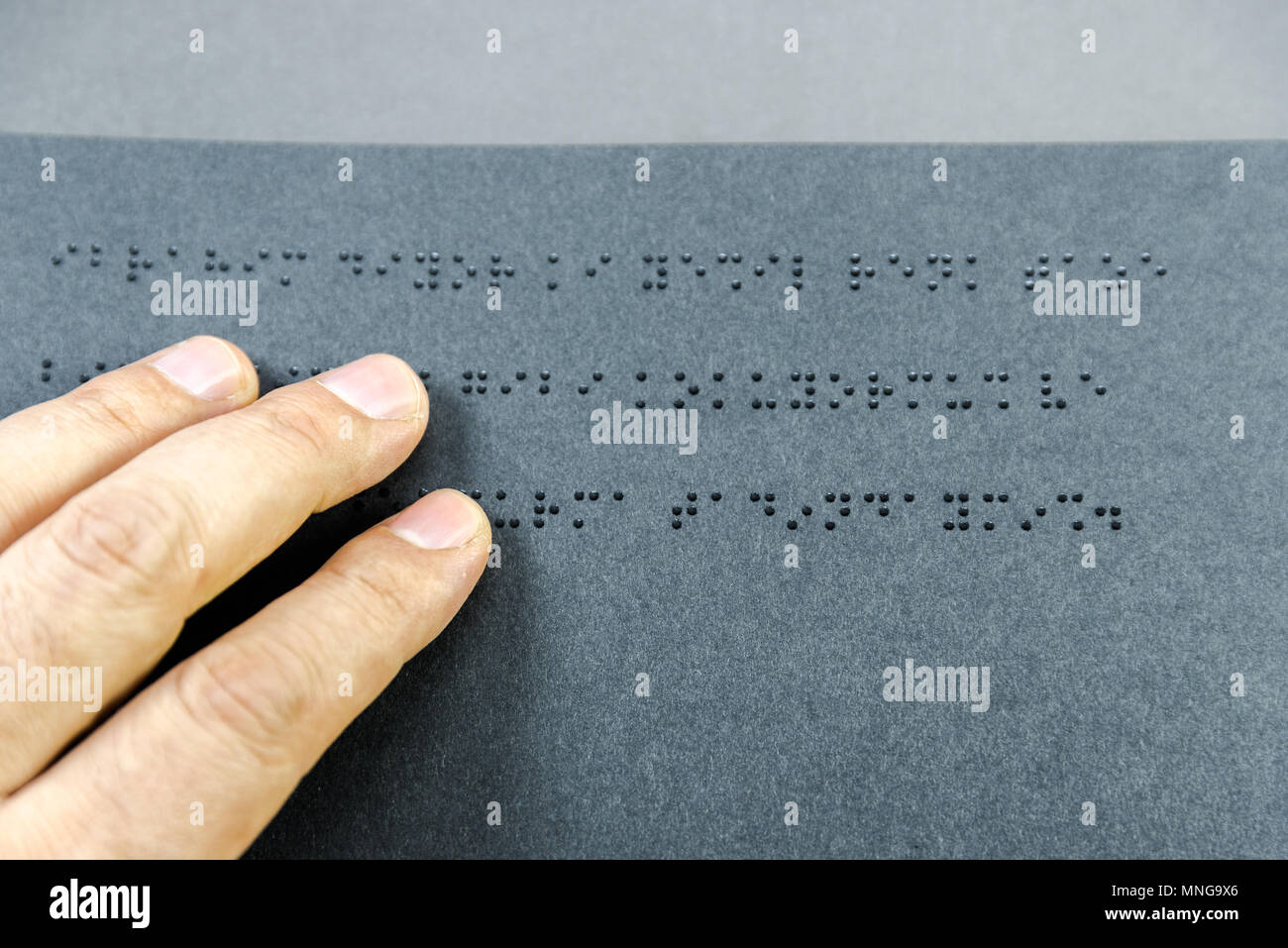 Top view of hand of a blind person reading a book written in braille ...