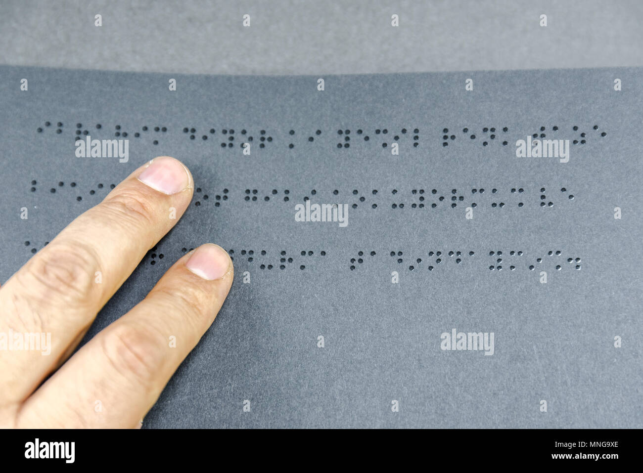 Top view of hand of a blind person reading a book written in braille ...
