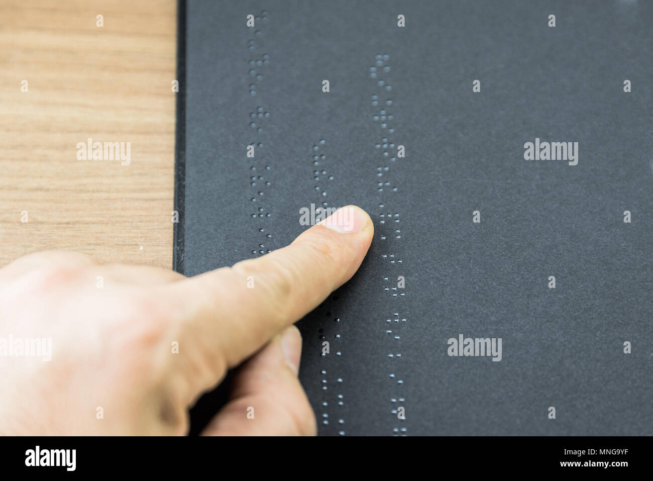 Top view of hand of a blind person reading a book written in braille ...