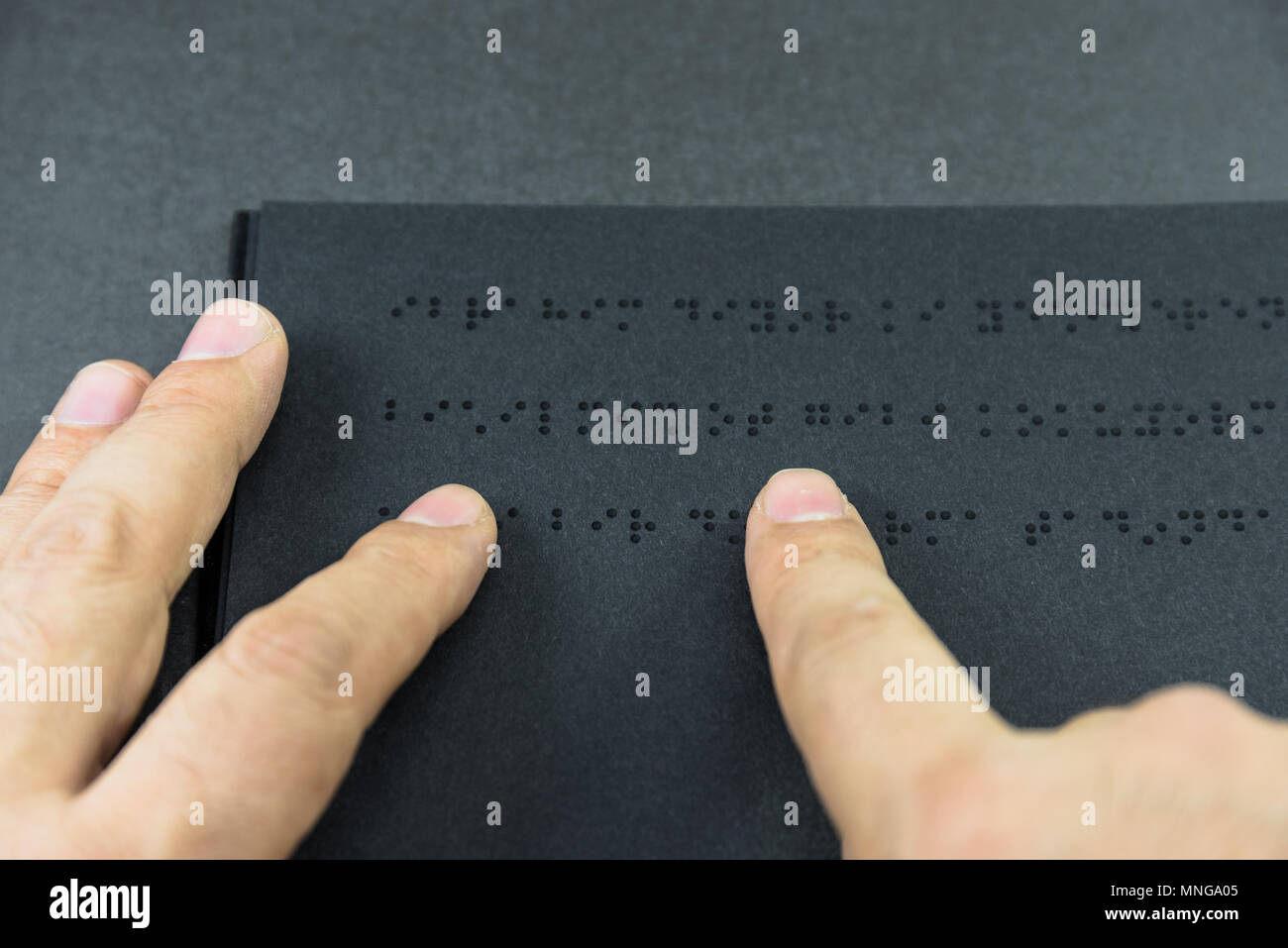 Top view of hand of a blind person reading a book written in braille ...
