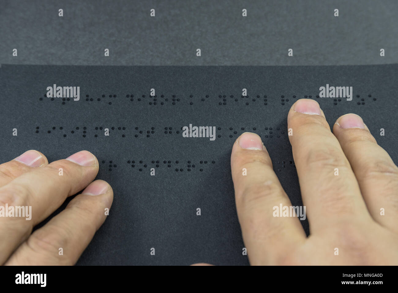 Top view of hand of a blind person reading a book written in braille ...