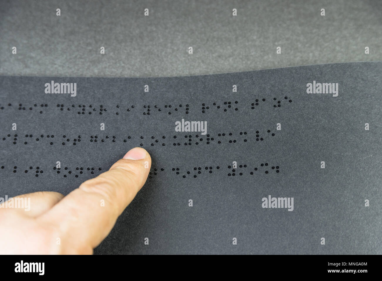 Top view of hand of a blind person reading a book written in braille ...
