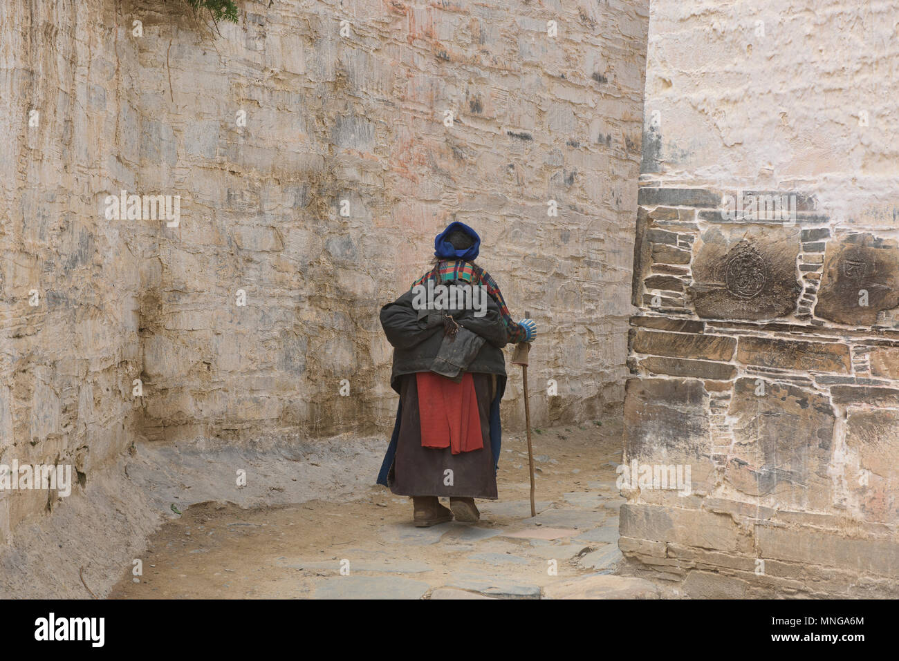 Tibetan pilgrim doing kora around Labrang Monastery, Xiahe, Gansu ...