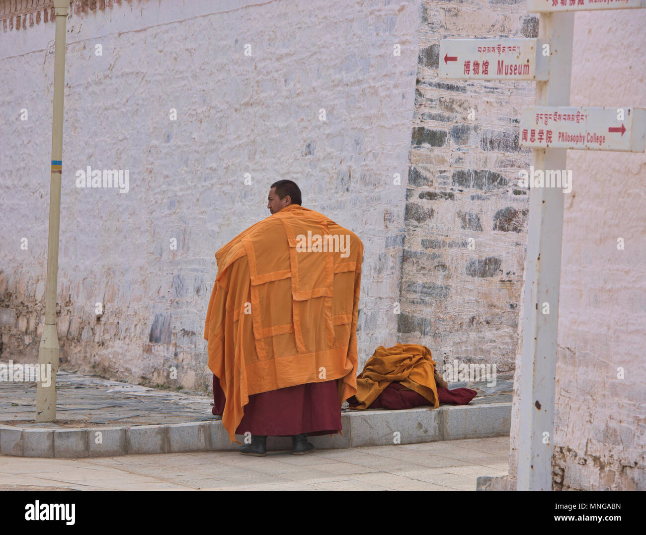 Gelukpa monk putting on his robe, Labrang Monastery, Xiahe, Gansu ...