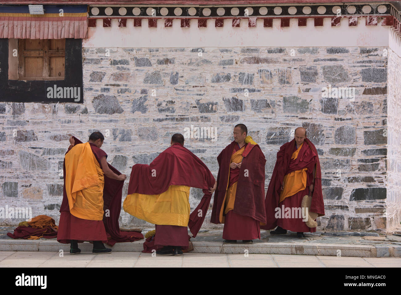 Gelukpa monks putting on their robes, Labrang Monastery, Xiahe, Gansu ...