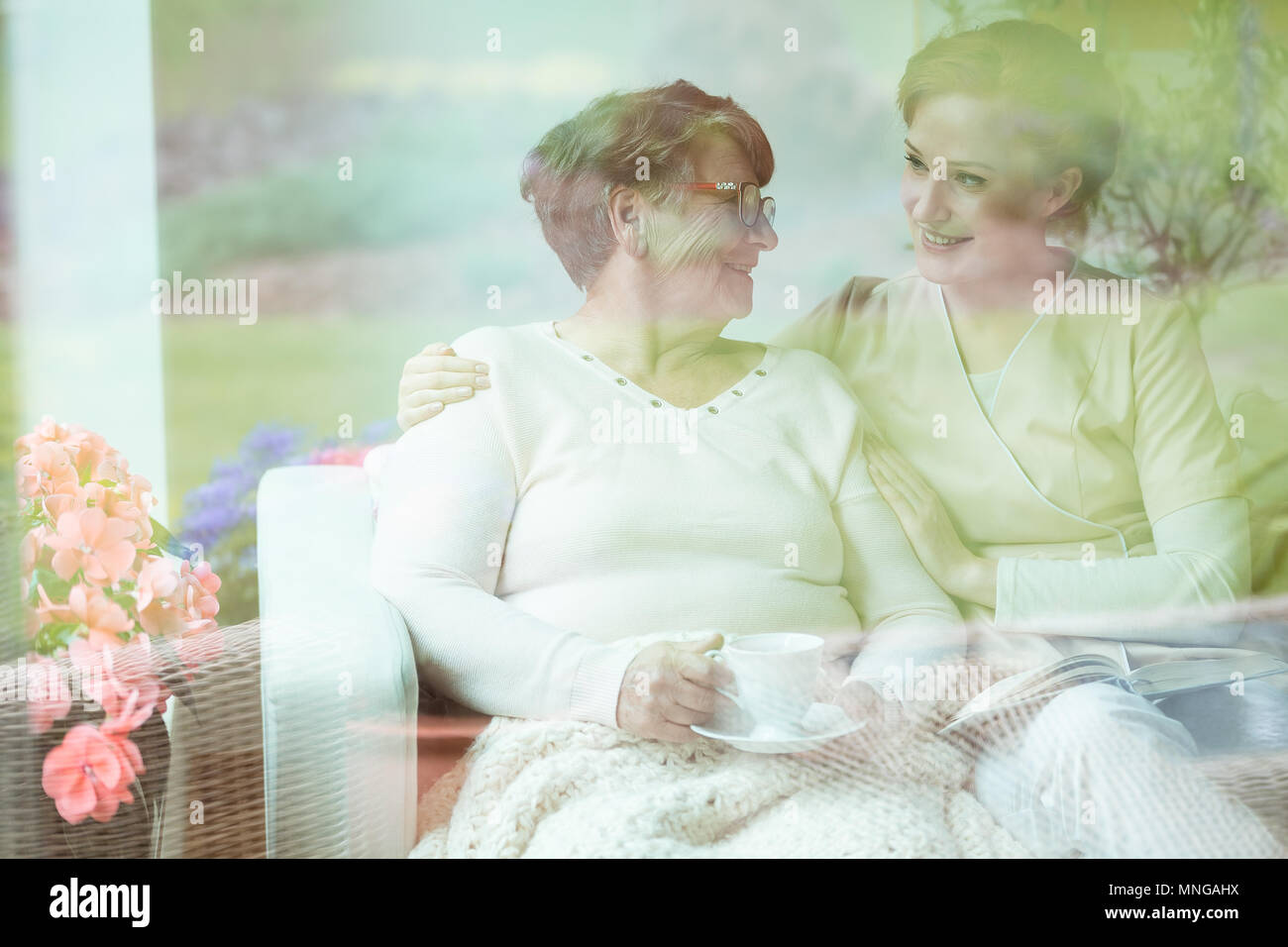 Through the window photo of grandchild hugging her disabled grandma ...