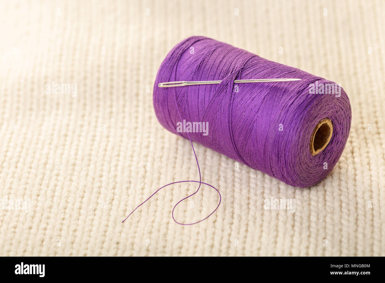 colored thread and buttons on white knitted fabric Stock Photo - Alamy