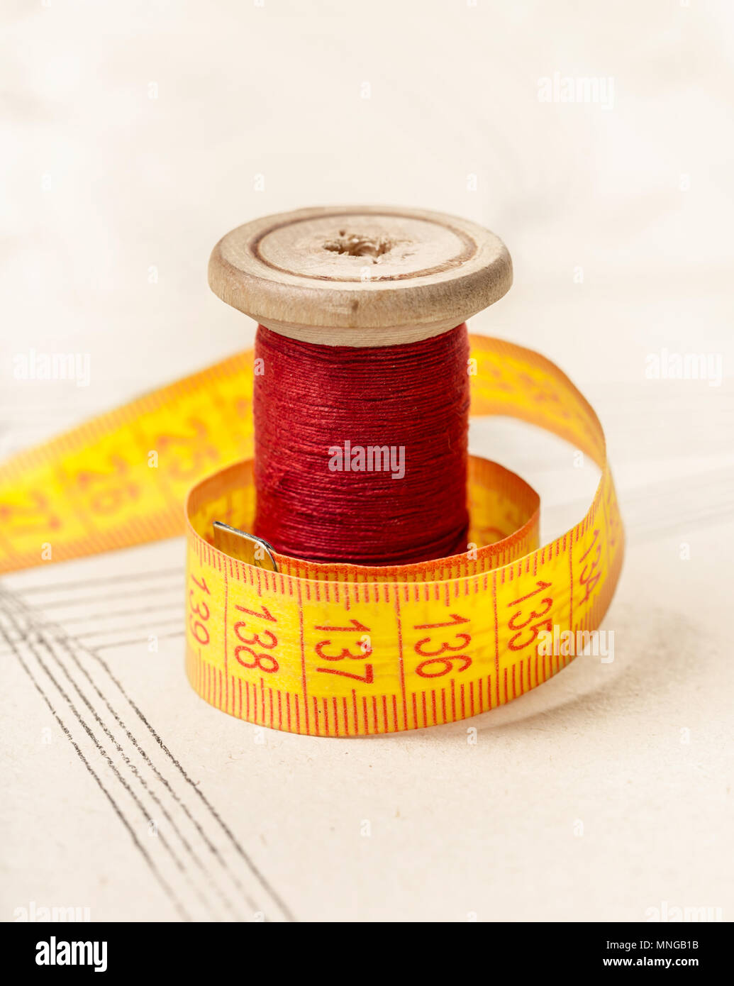 red thread and meter on background of paper pattern Stock Photo - Alamy