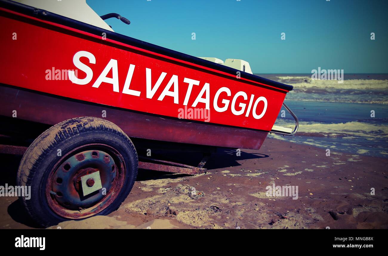 red boat on the beach with big text that means Rescue in Italian ...