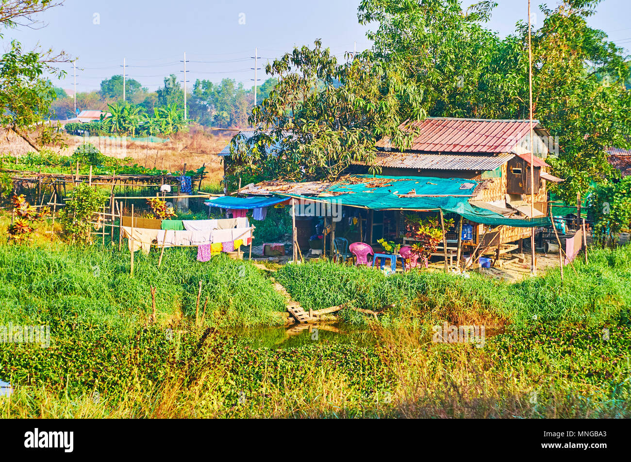 The shabby stilt slum house in farmlands of East Dagon Township of ...