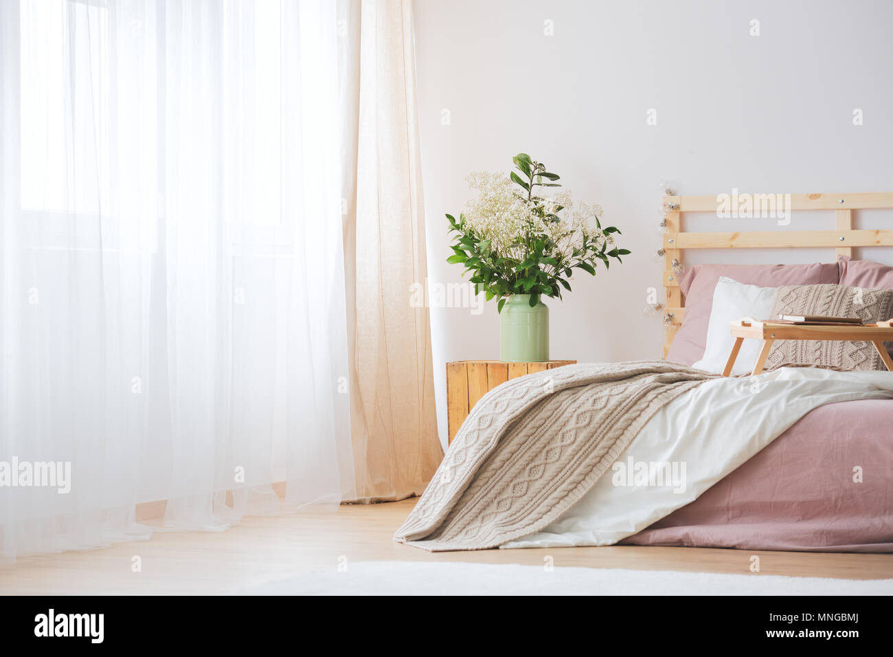 Cozy modern bedroom with big window, flowers and bed Stock Photo - Alamy