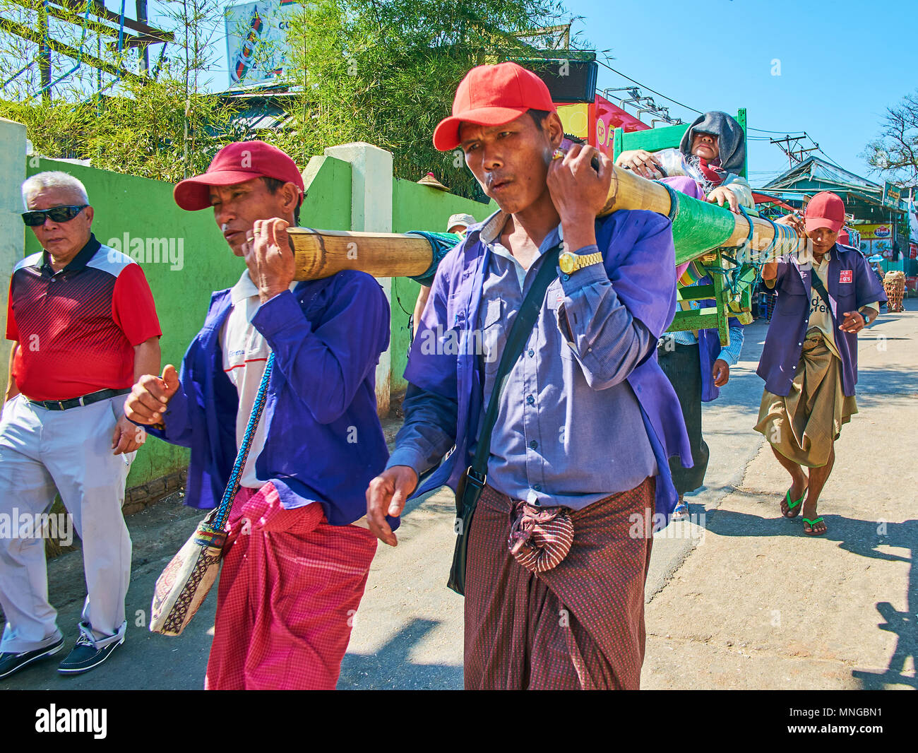 KYAIKTIYO, MYANMAR - FEBRUARY 16, 2018: The porters carry elderly ...
