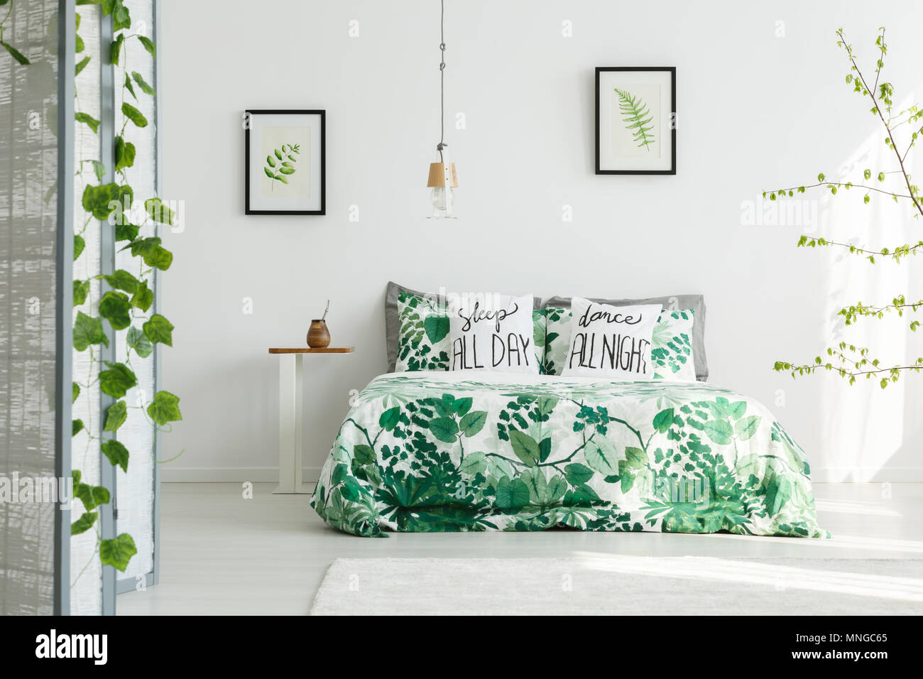 Botanical bedroom with white wall, double bed, leaf bedding Stock Photo ...