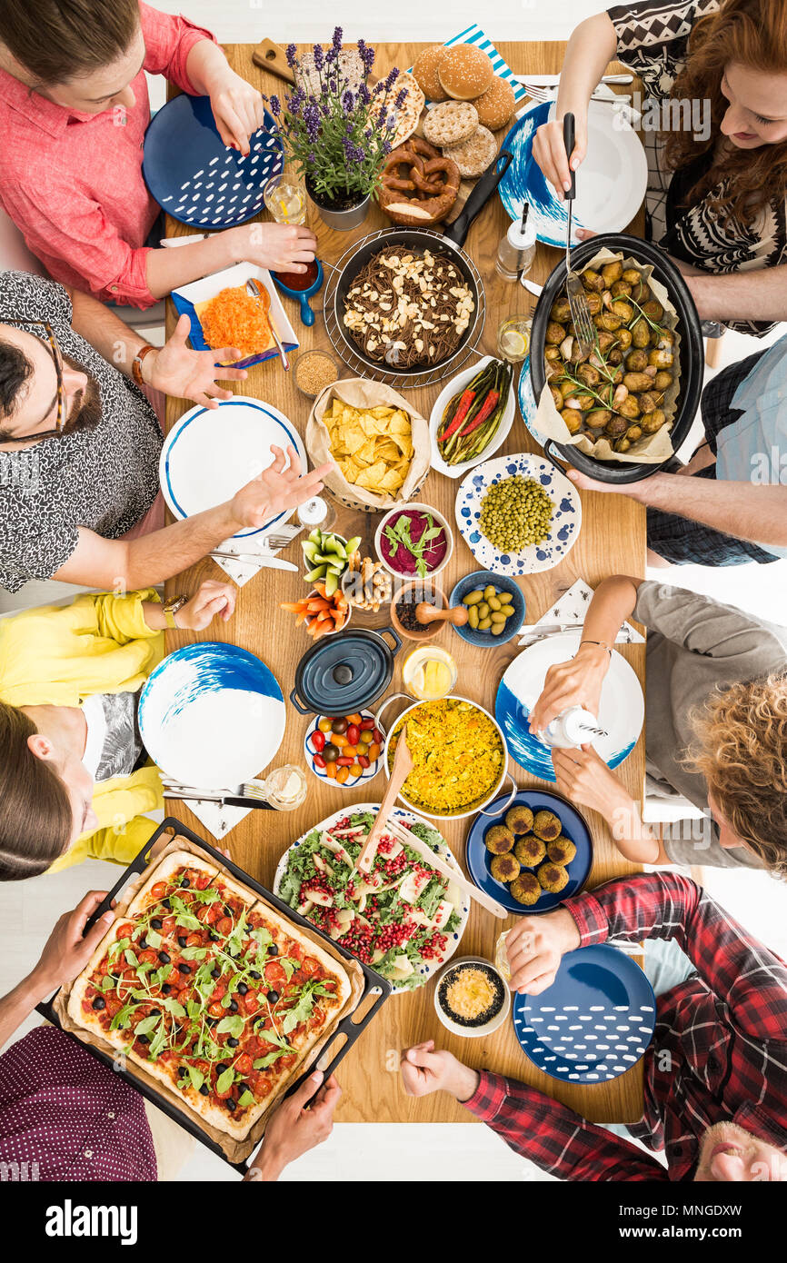 Vegetarians co-cook and eat healthy food at the common table with ...