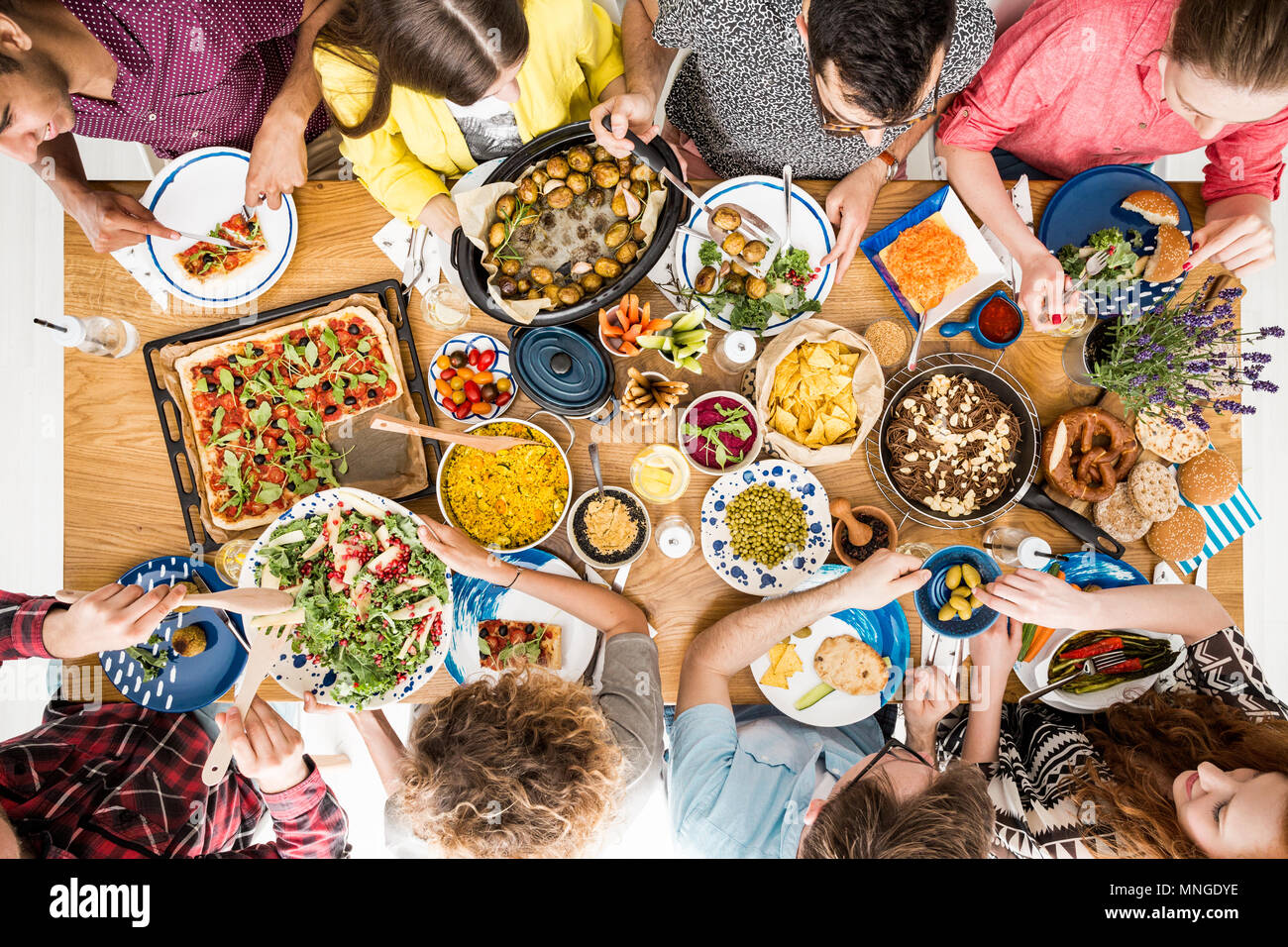 Common table with baked potatoes, pizza, hummus and bulgur groats ...