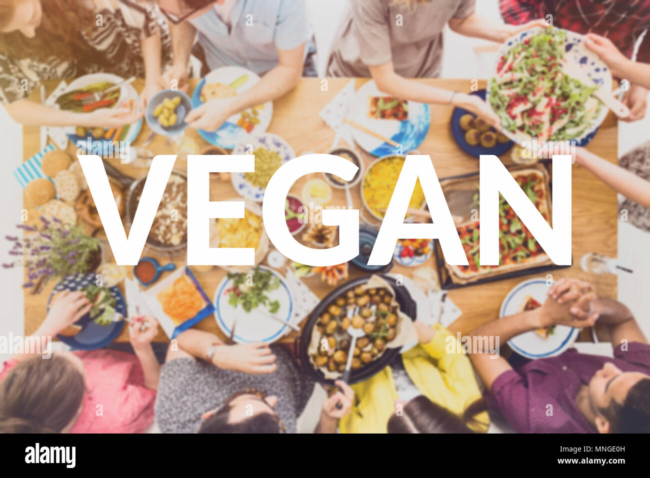 Vegetarians eat bio and organic meal at common table in home. Vegan ...