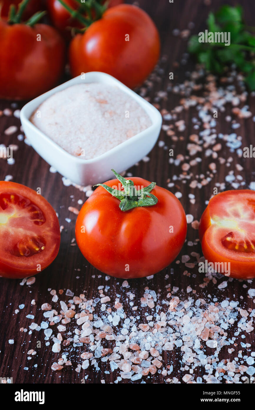 Organic tomatoes and rock salt on a wooden background Stock Photo - Alamy