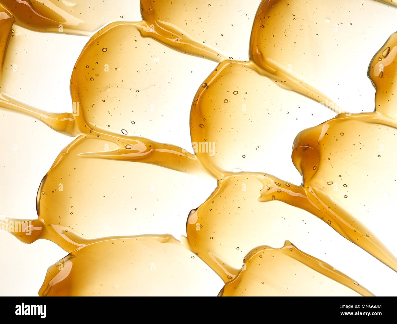 Transparent yellow smear of face cream or golden honey isolated on ...