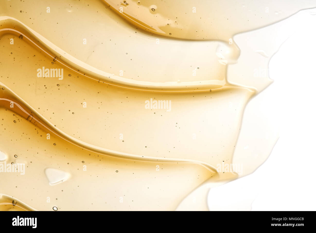 Transparent yellow smear of face cream or golden honey isolated on ...