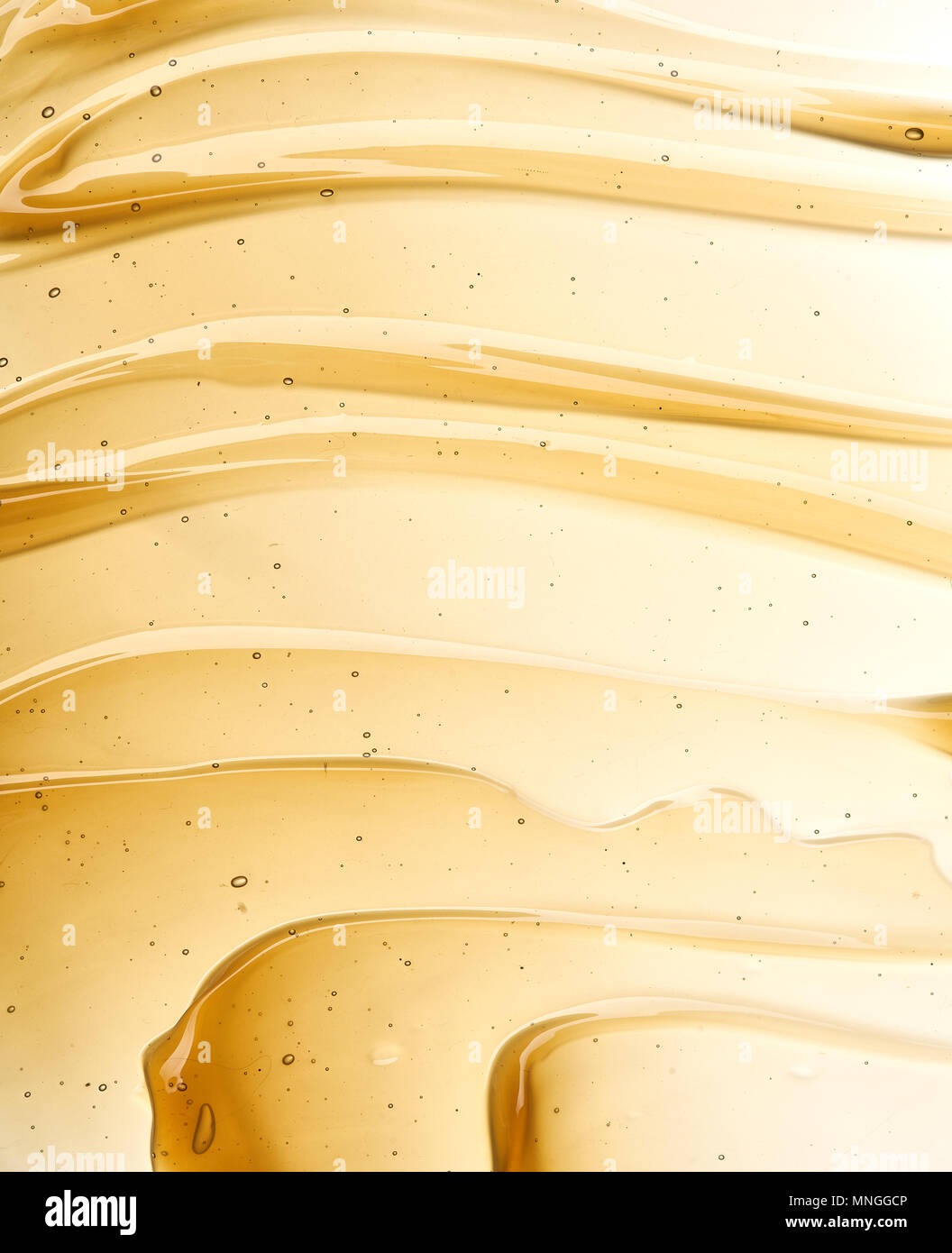 Transparent yellow smear of face cream or golden honey isolated on ...