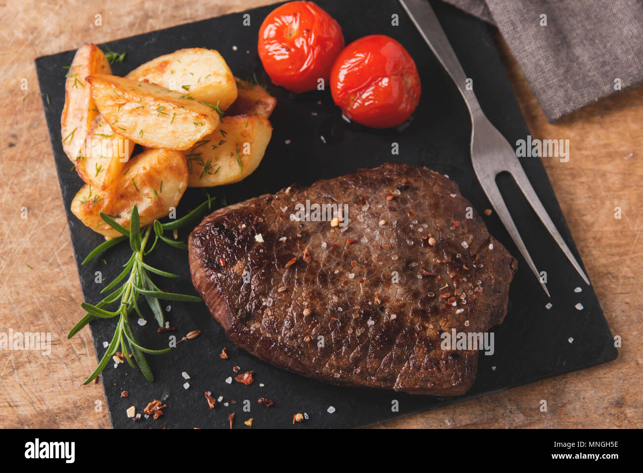 cooked grill beef steak with fried potatoes and tomatoes Stock Photo - Alamy