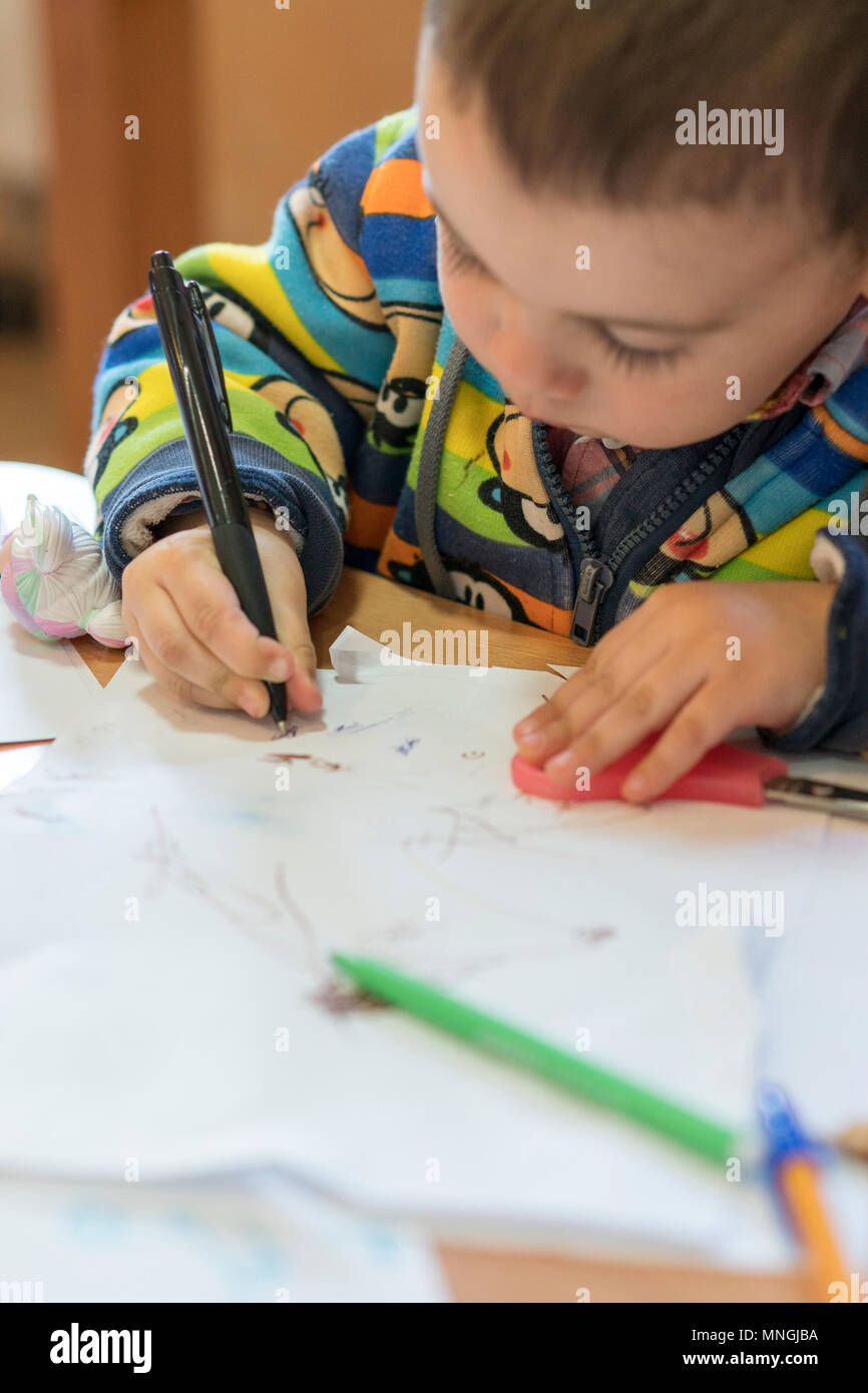 Cute little boy writing something in notebook Stock Photo - Alamy