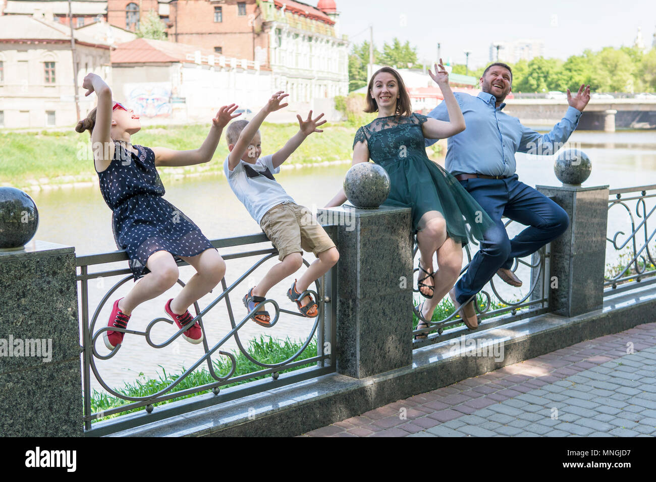 Family plays the fool pretending to fall off the railing into the river ...
