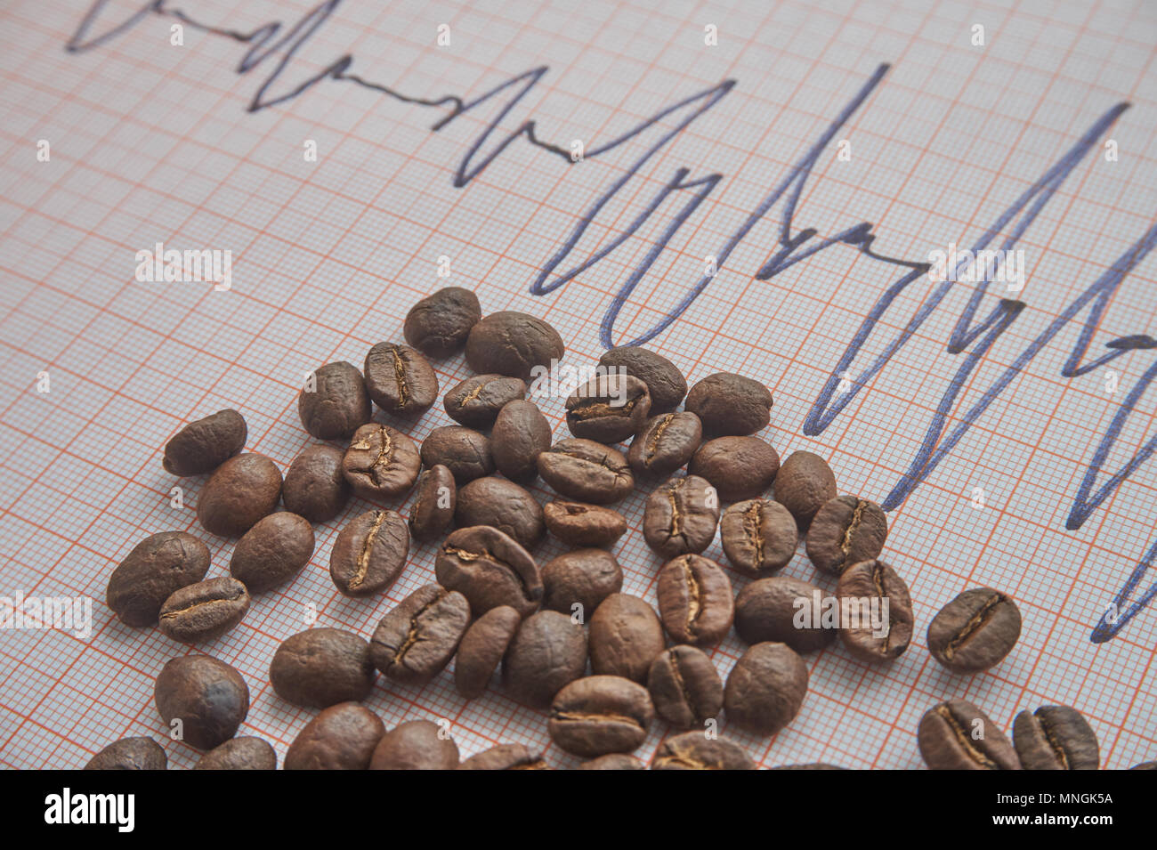 Loose roasted coffee beans on an ECG tracing showing an increased heart ...