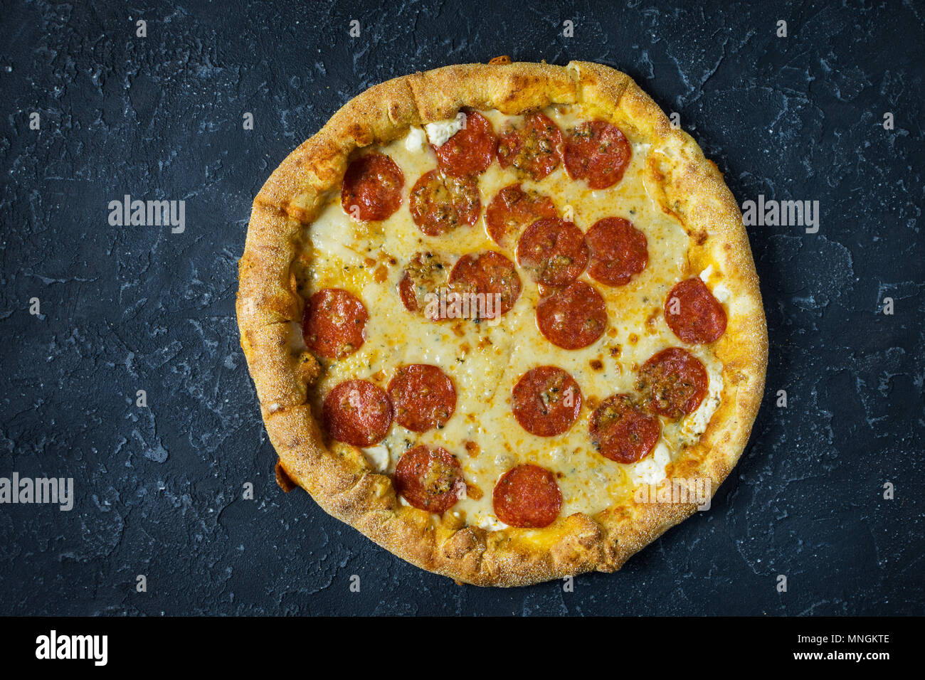 Pepperoni pizza on rustic, vintage style. Top view on dark stone table ...