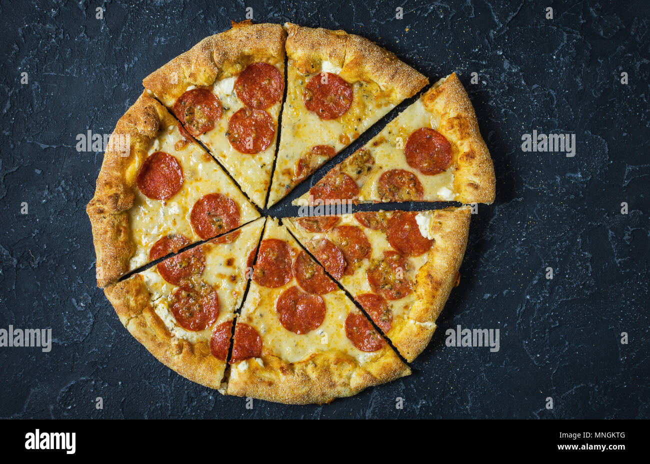 Pepperoni pizza on rustic, vintage style. Top view on dark stone table ...
