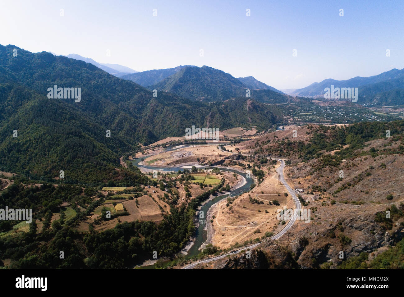 A picturesque mountain landscape with a road and a river. Aerial ...